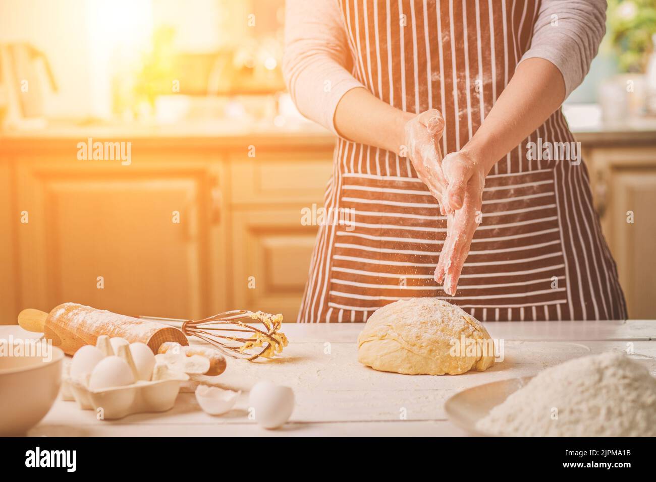 Woman slap his hands above dough closeup. Baker finishing his bakery ...