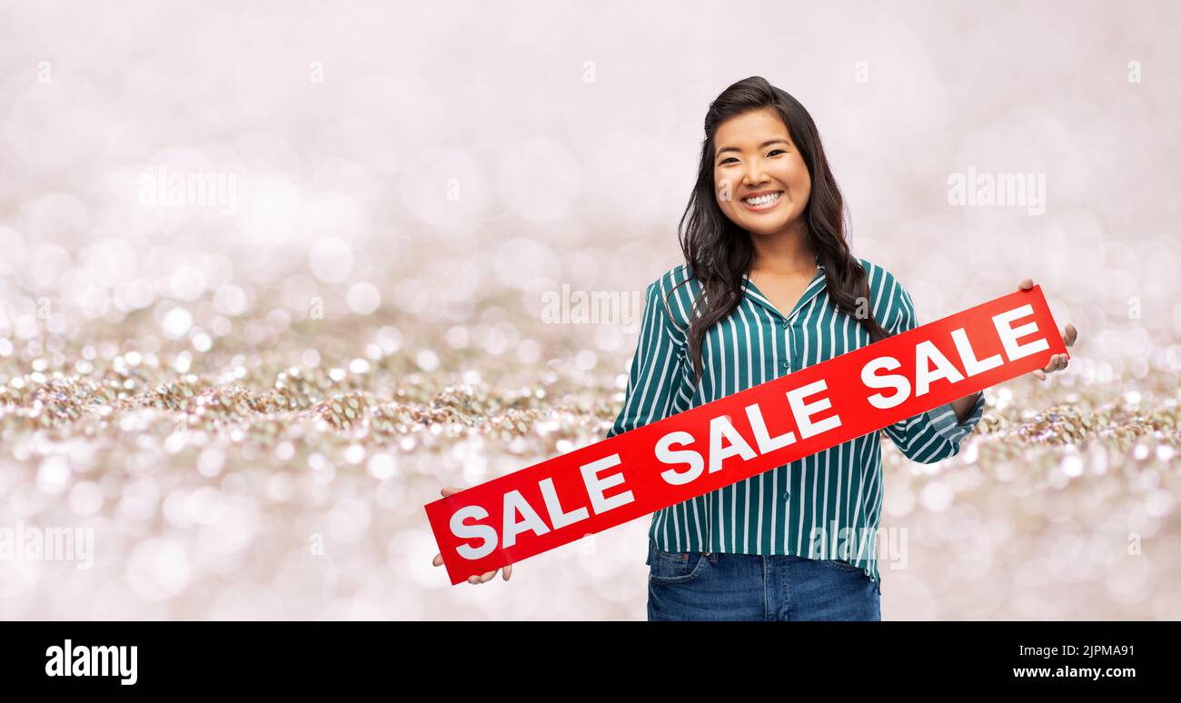 happy smiling young asian woman with sale banner Stock Photo - Alamy