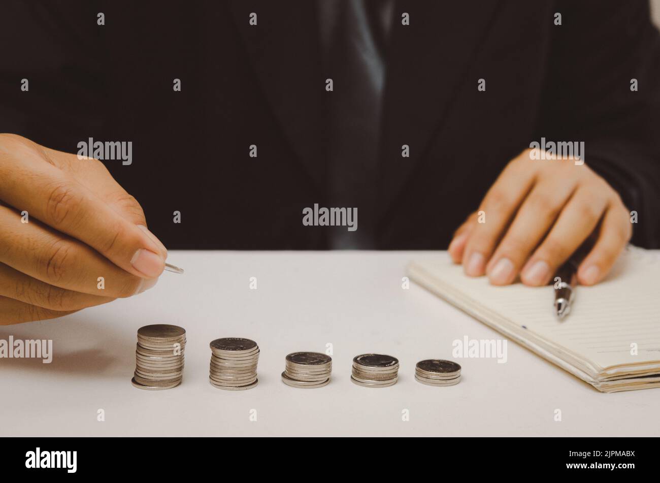 Man hand coin saving money finance growth economy accounting on desk ...