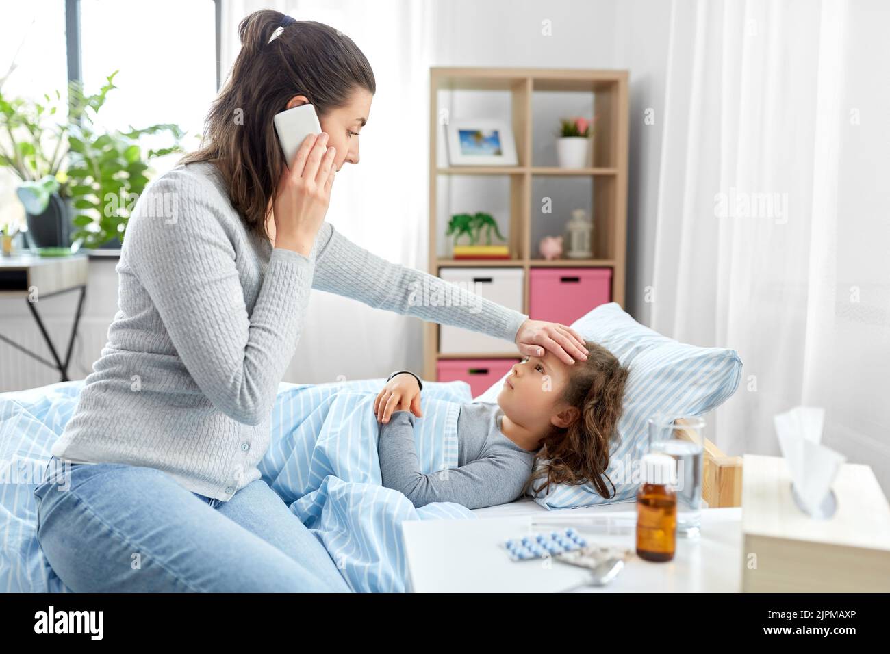 ill daughter and mother calling on phone at home Stock Photo - Alamy