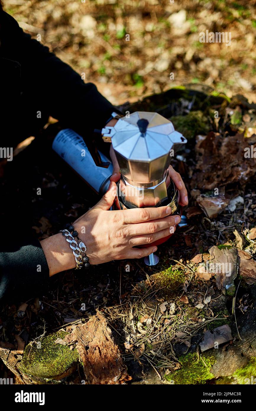 Man brewing coffee from a geyser coffee maker on a gas burner,, autumn ...