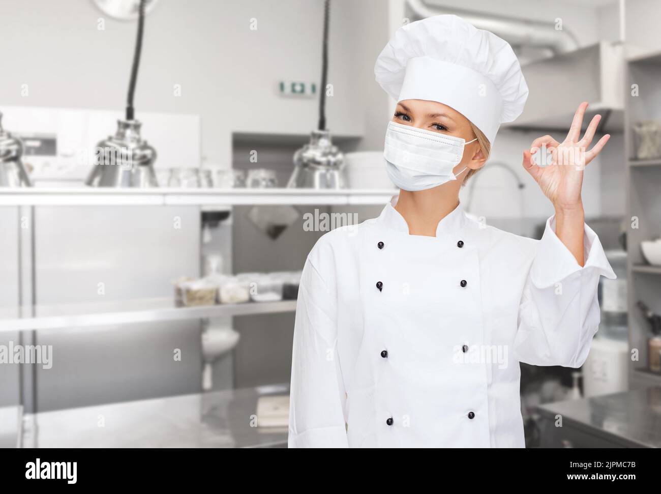 female chef in mask showing ok sign at kitchen Stock Photo - Alamy