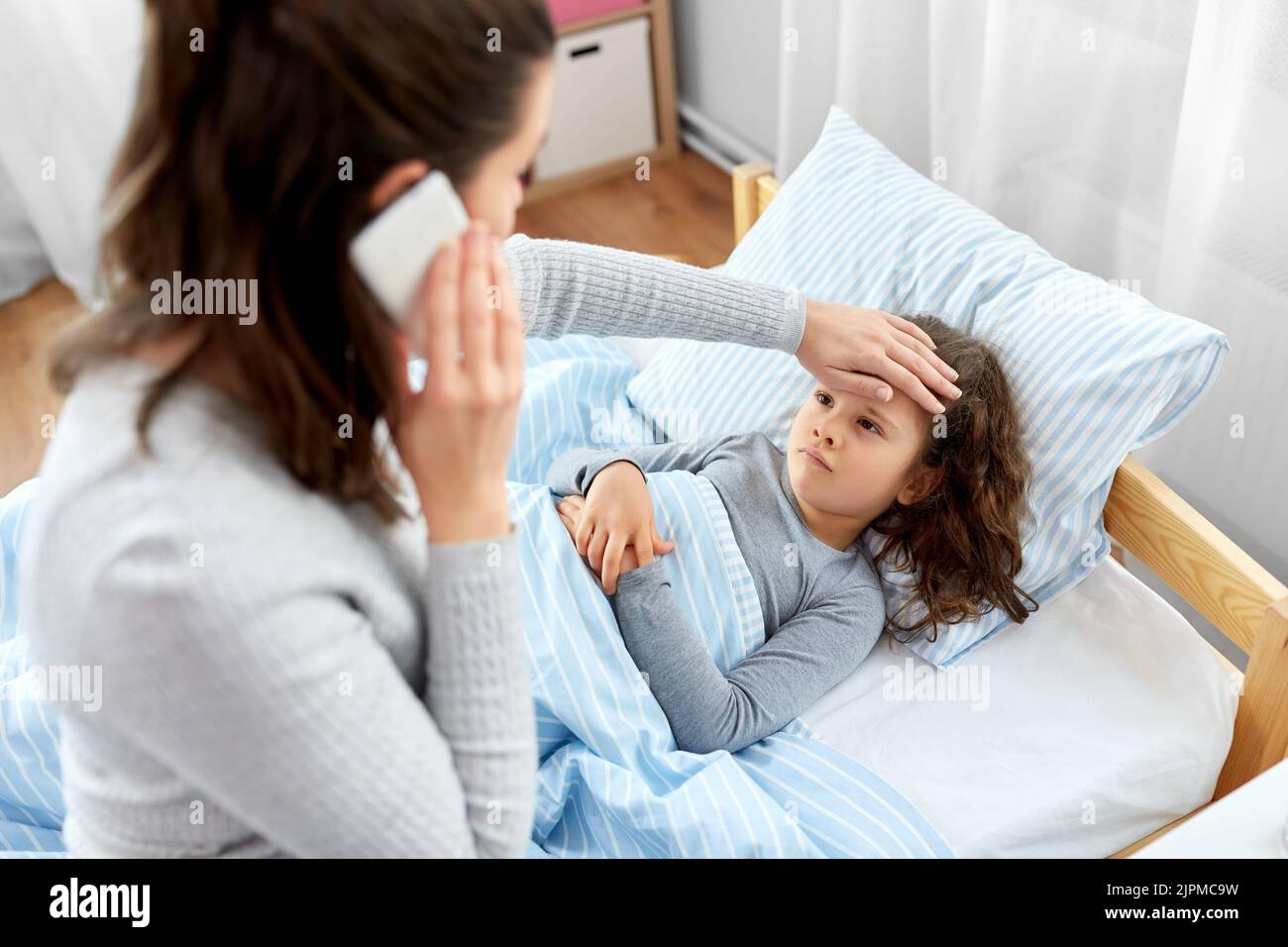 ill daughter and mother calling on phone at home Stock Photo - Alamy