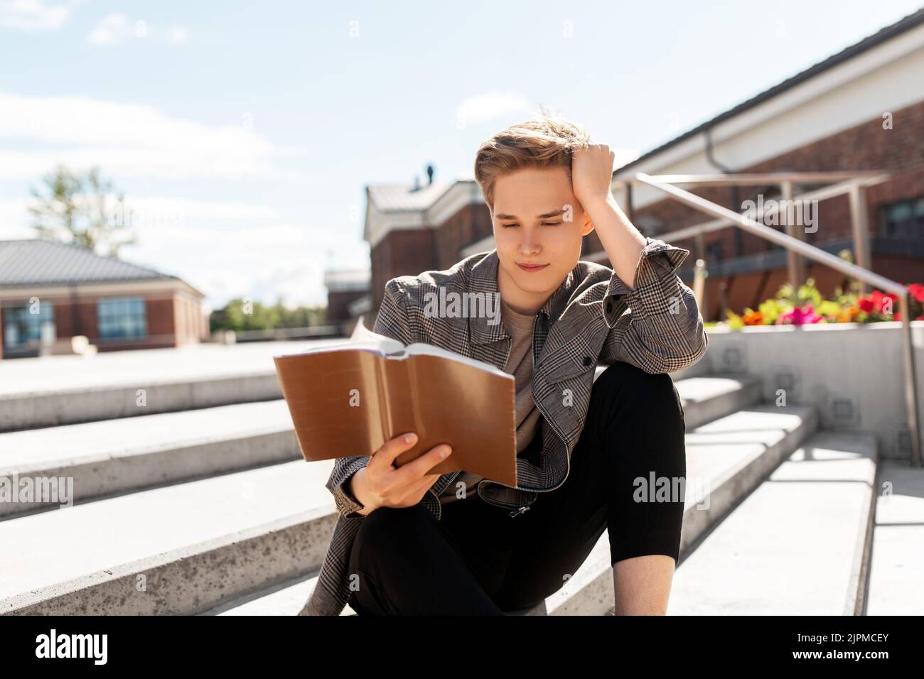 Happy teenage boy reading book hi-res stock photography and images - Alamy