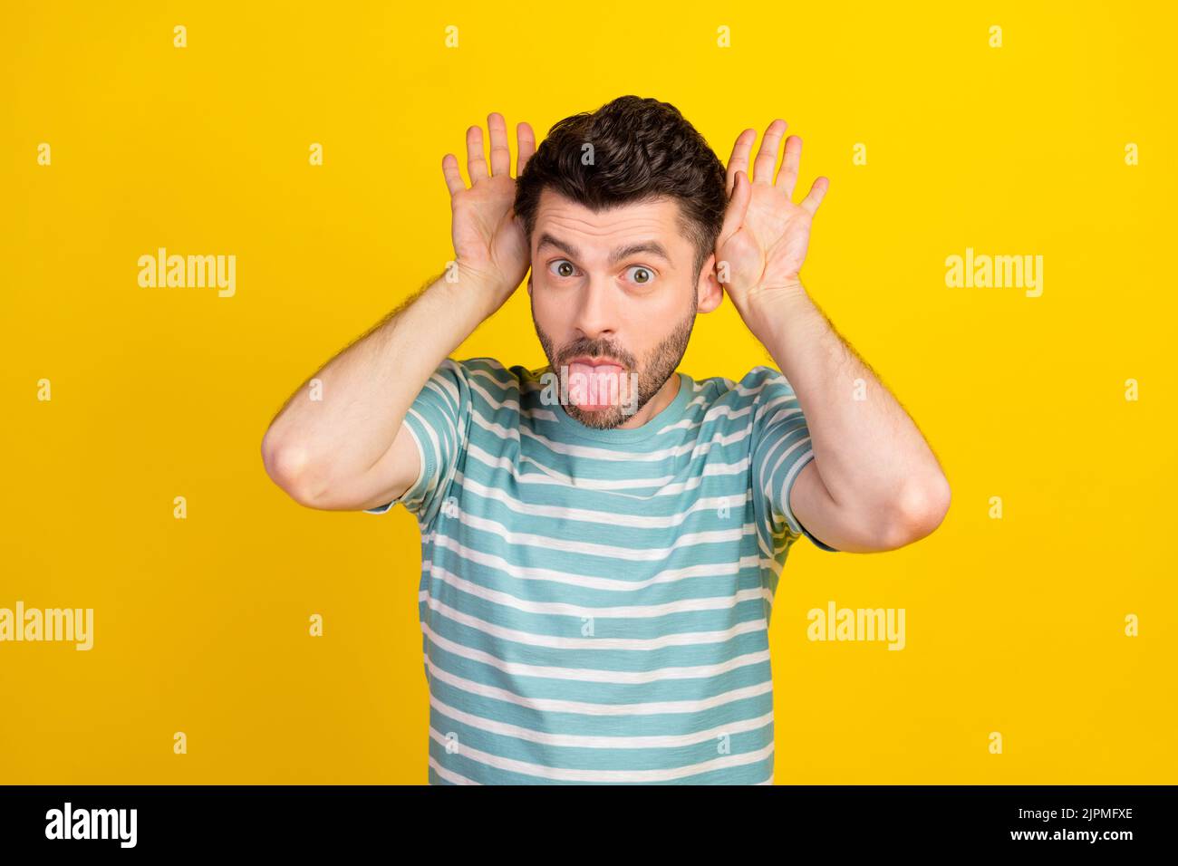 Portrait of young handsome silly guy have vacation playful showing ...