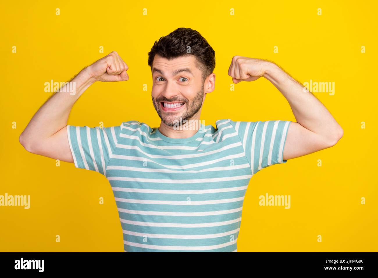 Photo of young positive man arm flex show biceps toothy smile look ...