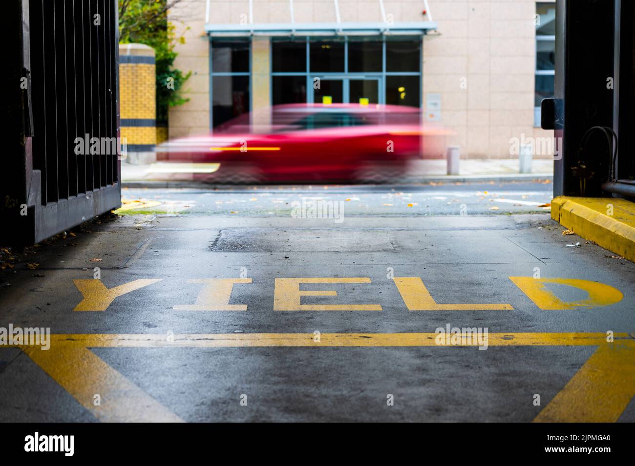Worn yellow yield sign at the exit of a car park near Tallaght Square ...