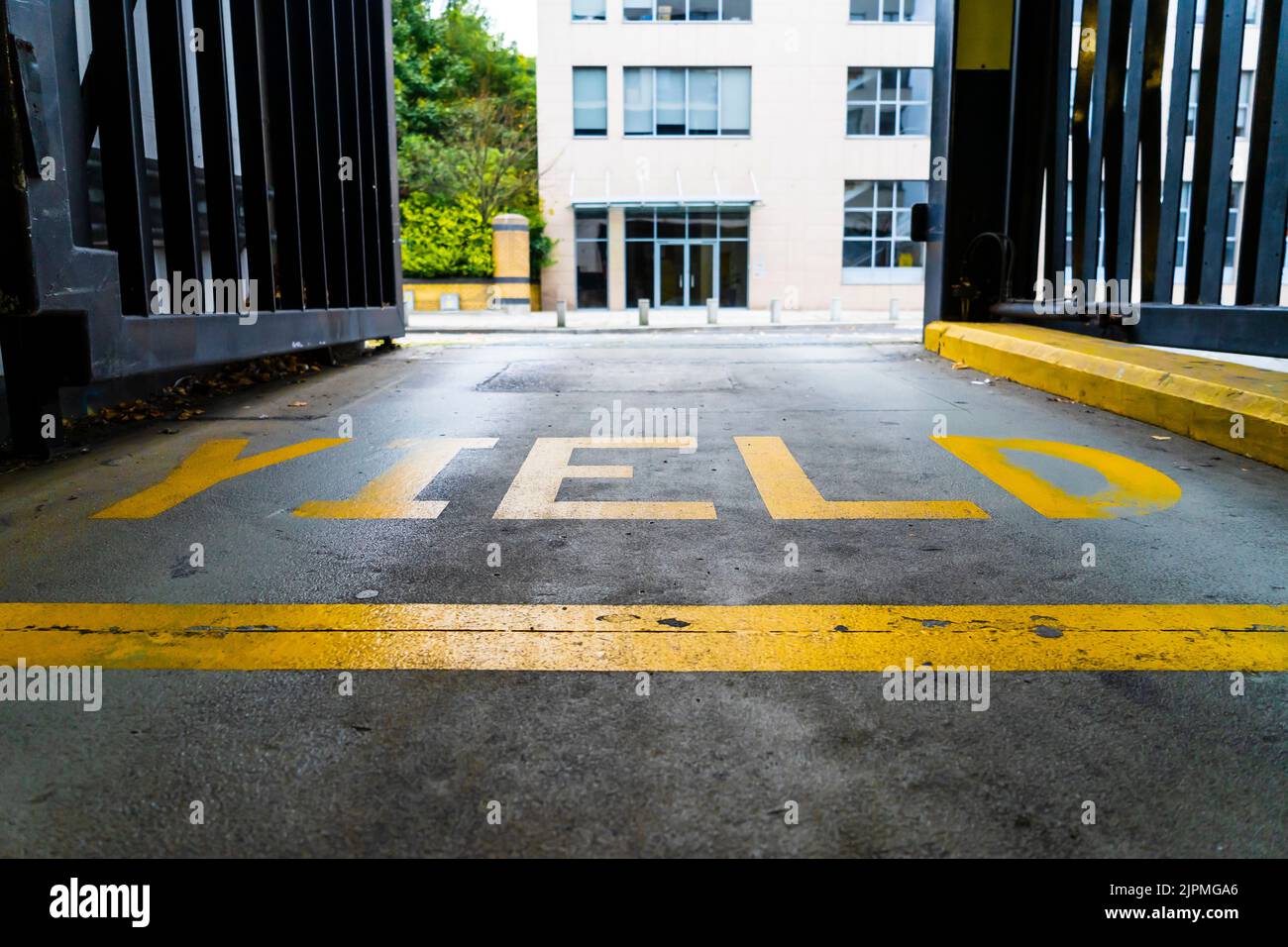 Worn yellow yield sign at the exit of a car park near Tallaght Square ...