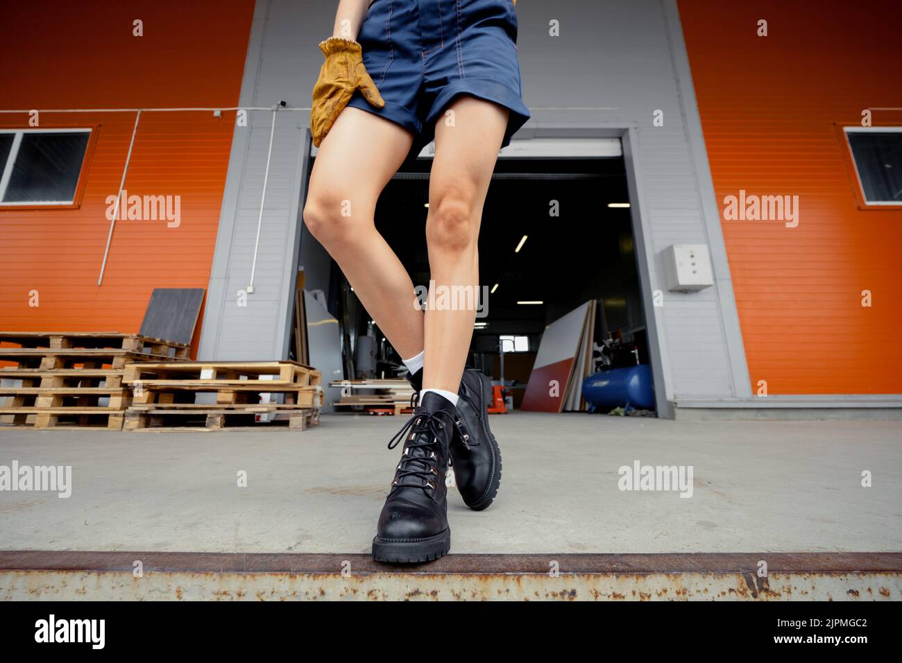 Low angle view at female legs in uniform and rough boots standing on ...