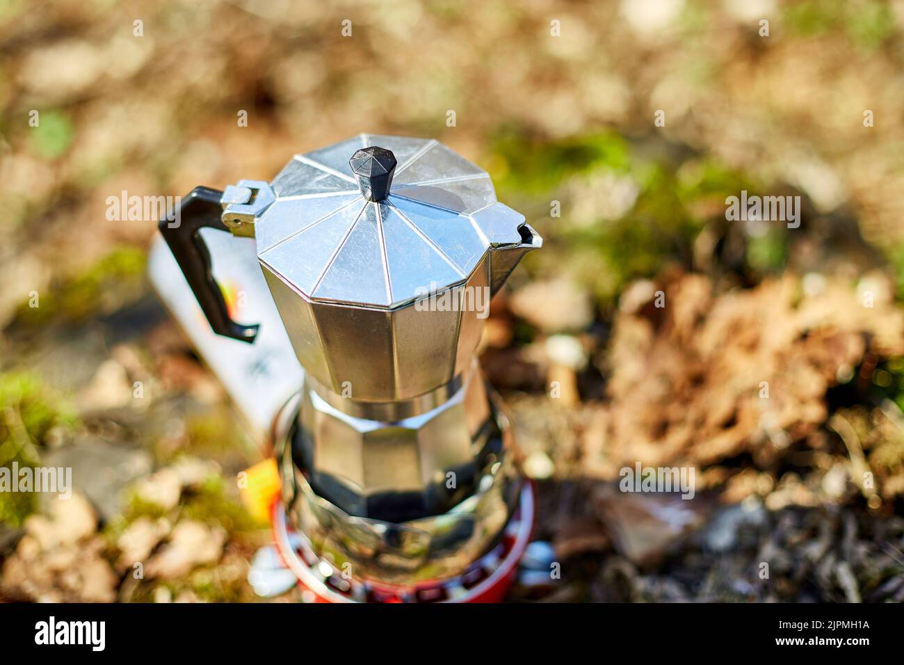 Making camping coffee from a geyser coffee maker on a gas burner ...