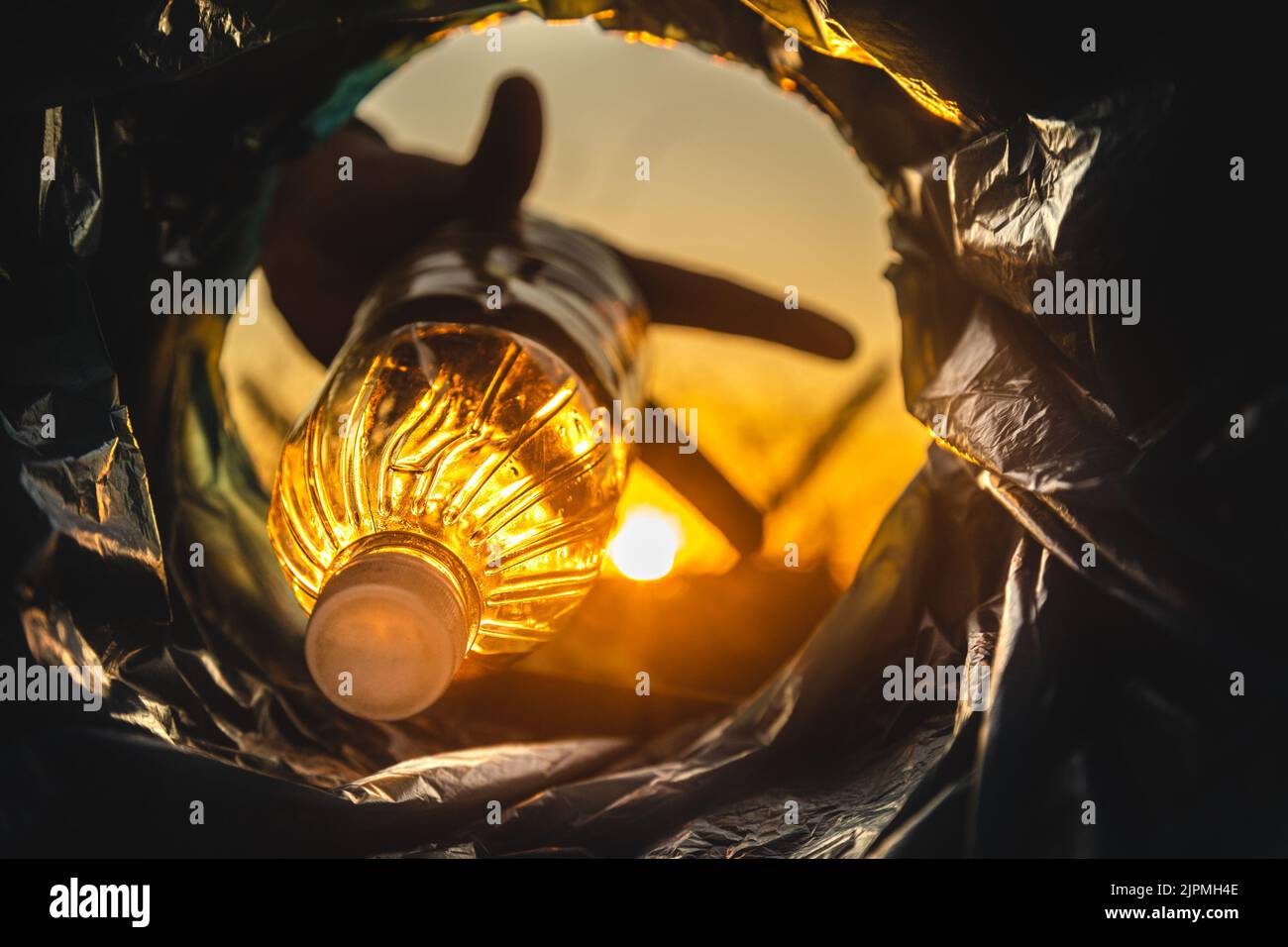 Close-up of a hand throwing a plastic bottle into the trash can. Close ...