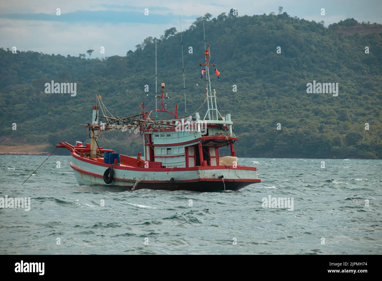 A Khmer fishing boat on a rough sea during the monsoon in Koh Sdach ...
