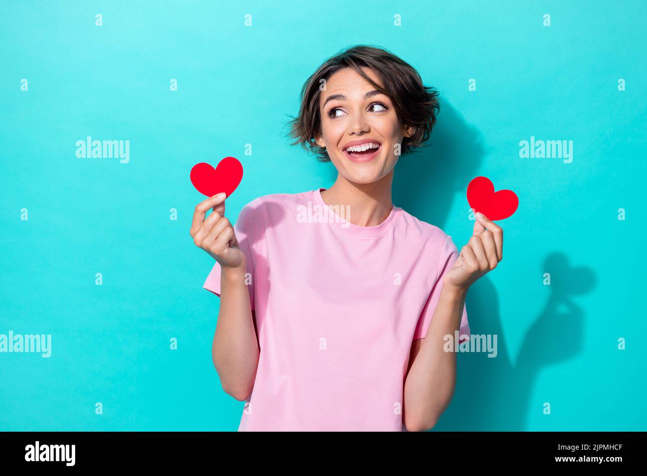 Portrait photo of young cute funny smiling woman hold paper red symbol ...