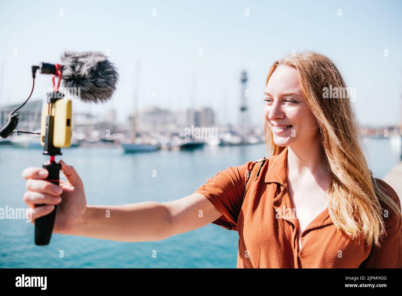 female travel vlogger streaming near sea in a touristic destination ...