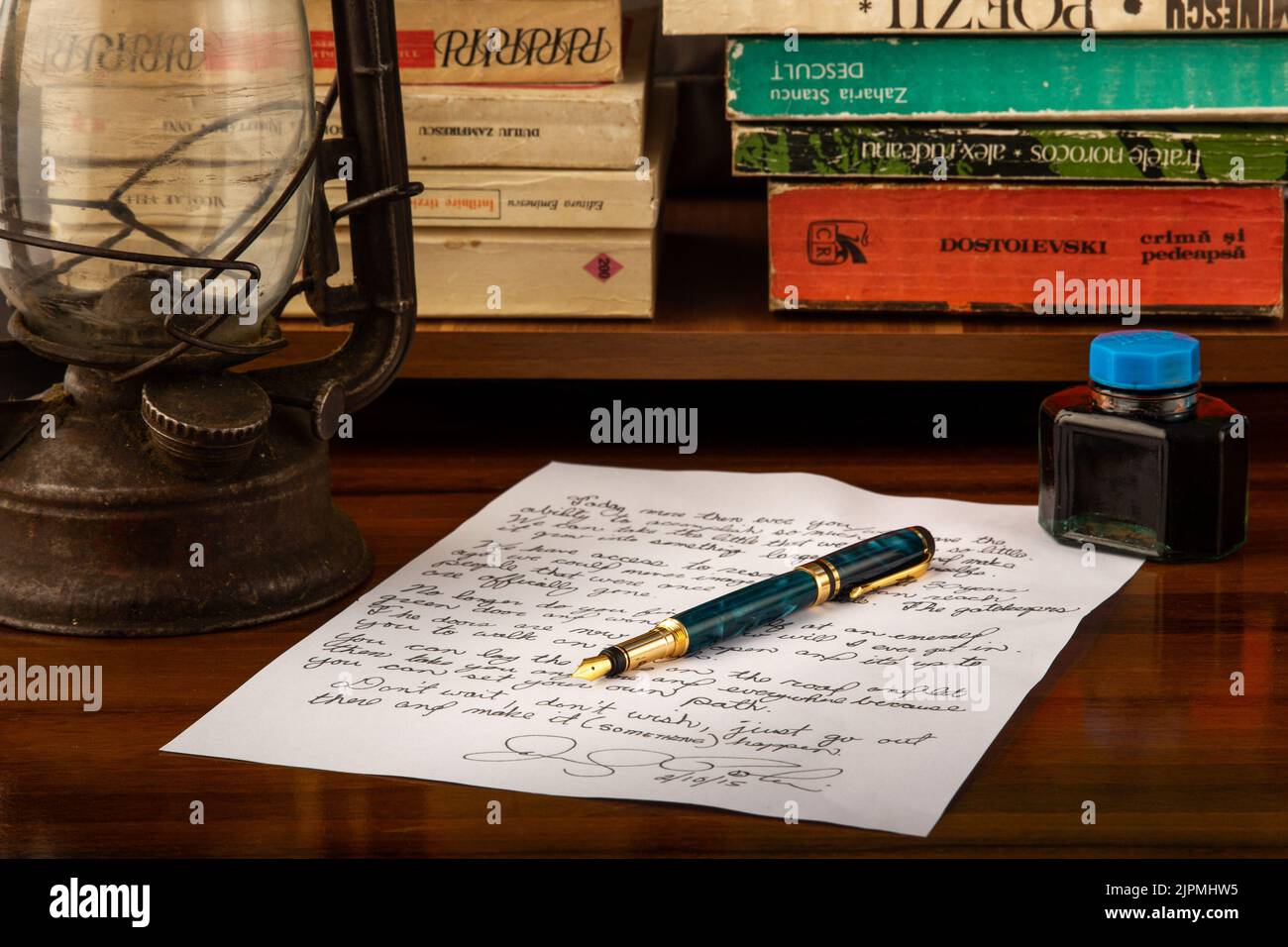 A pen on top of a letter on a desk with old book on a background Stock ...