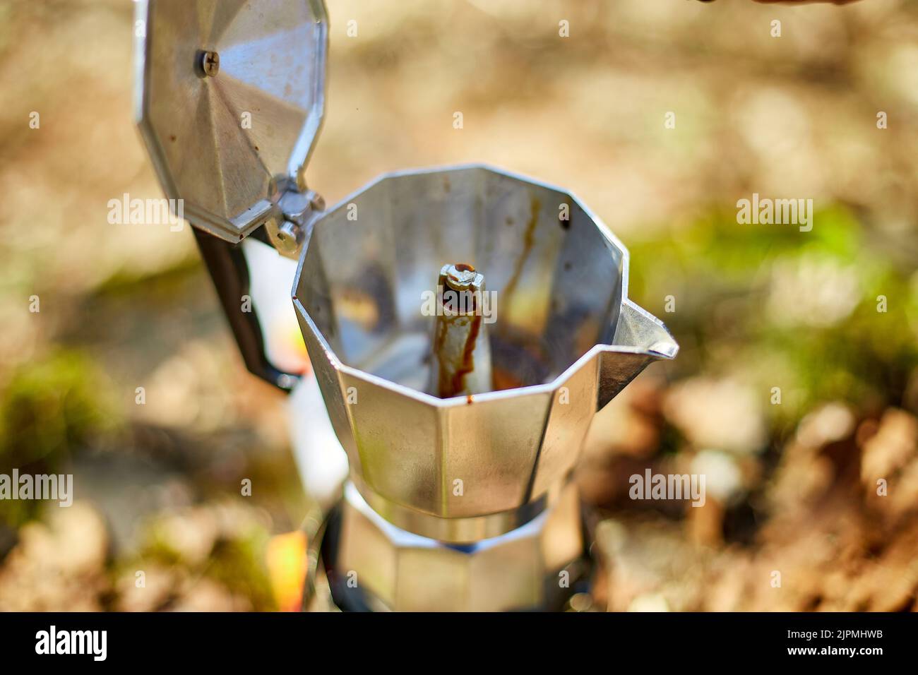 Making camping coffee from a geyser coffee maker on a gas burner ...