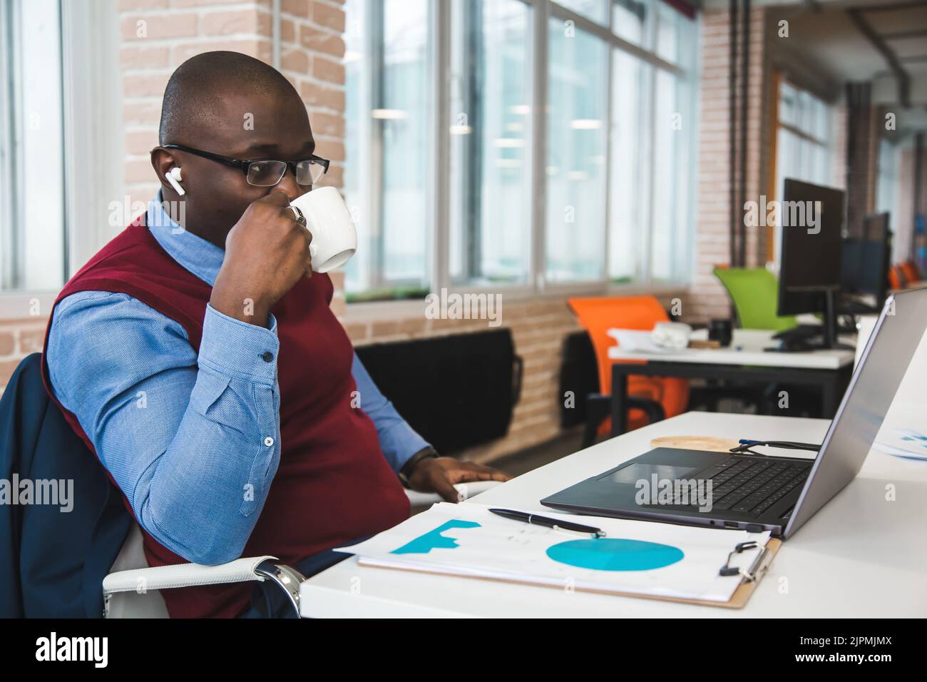 Dark-skinned African American businessman student work behind a laptop ...