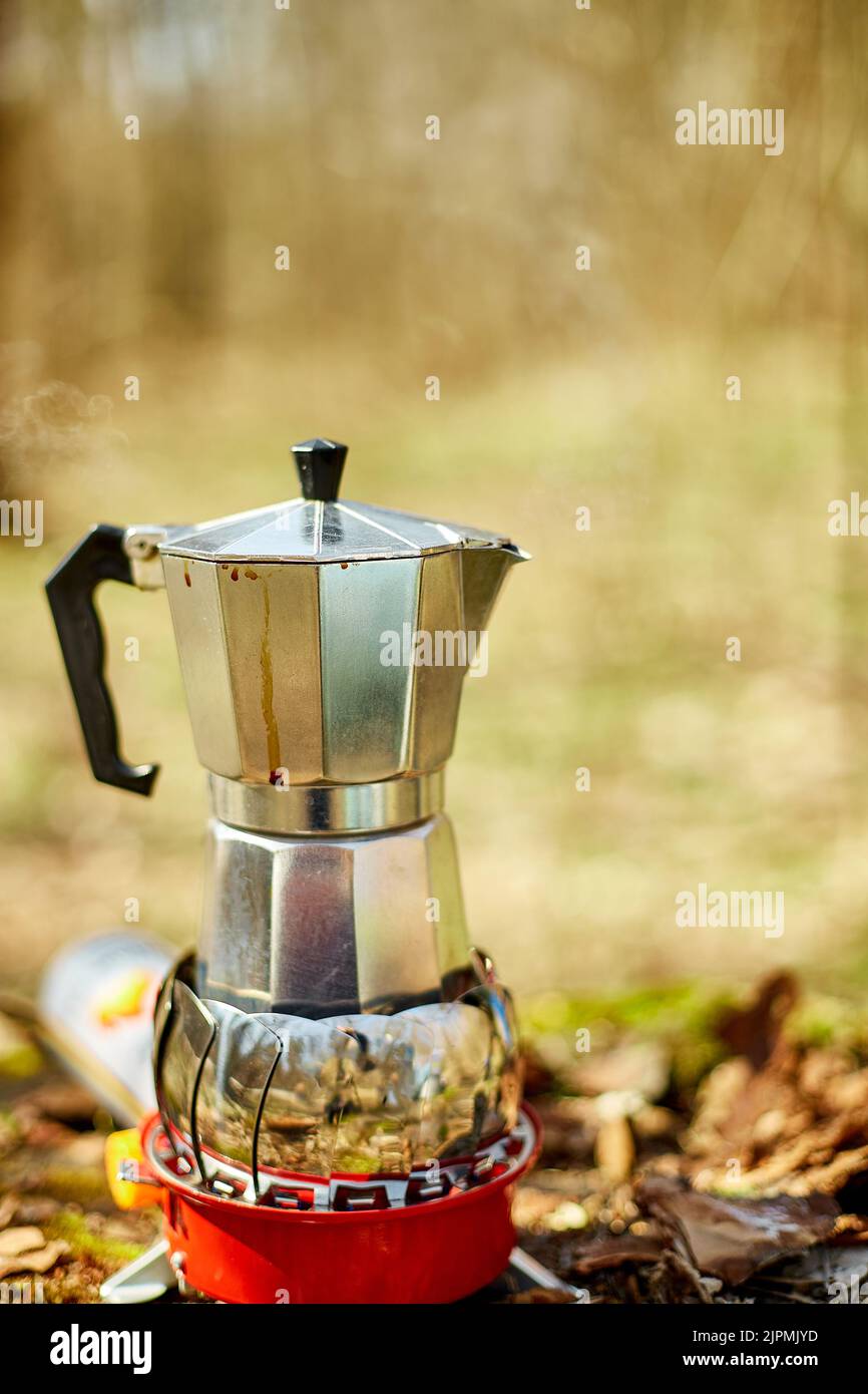 Making camping coffee from a geyser coffee maker on a gas burner ...