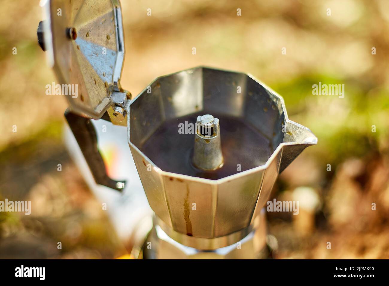 Making camping coffee from a geyser coffee maker on a gas burner ...