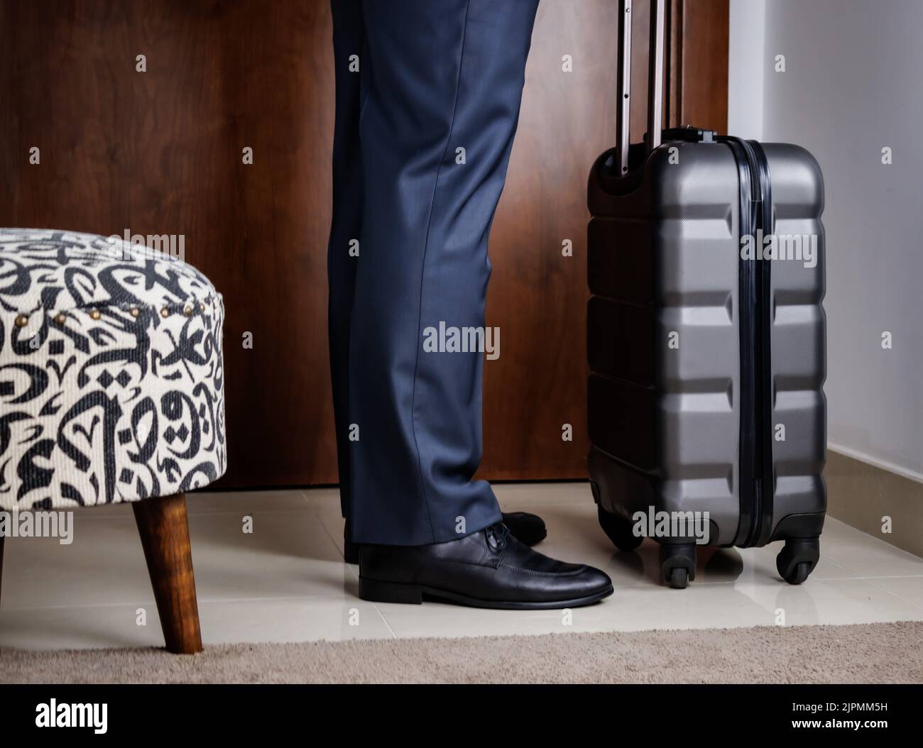 An unrecognizable businessman about to leave the house with a suitcase ...