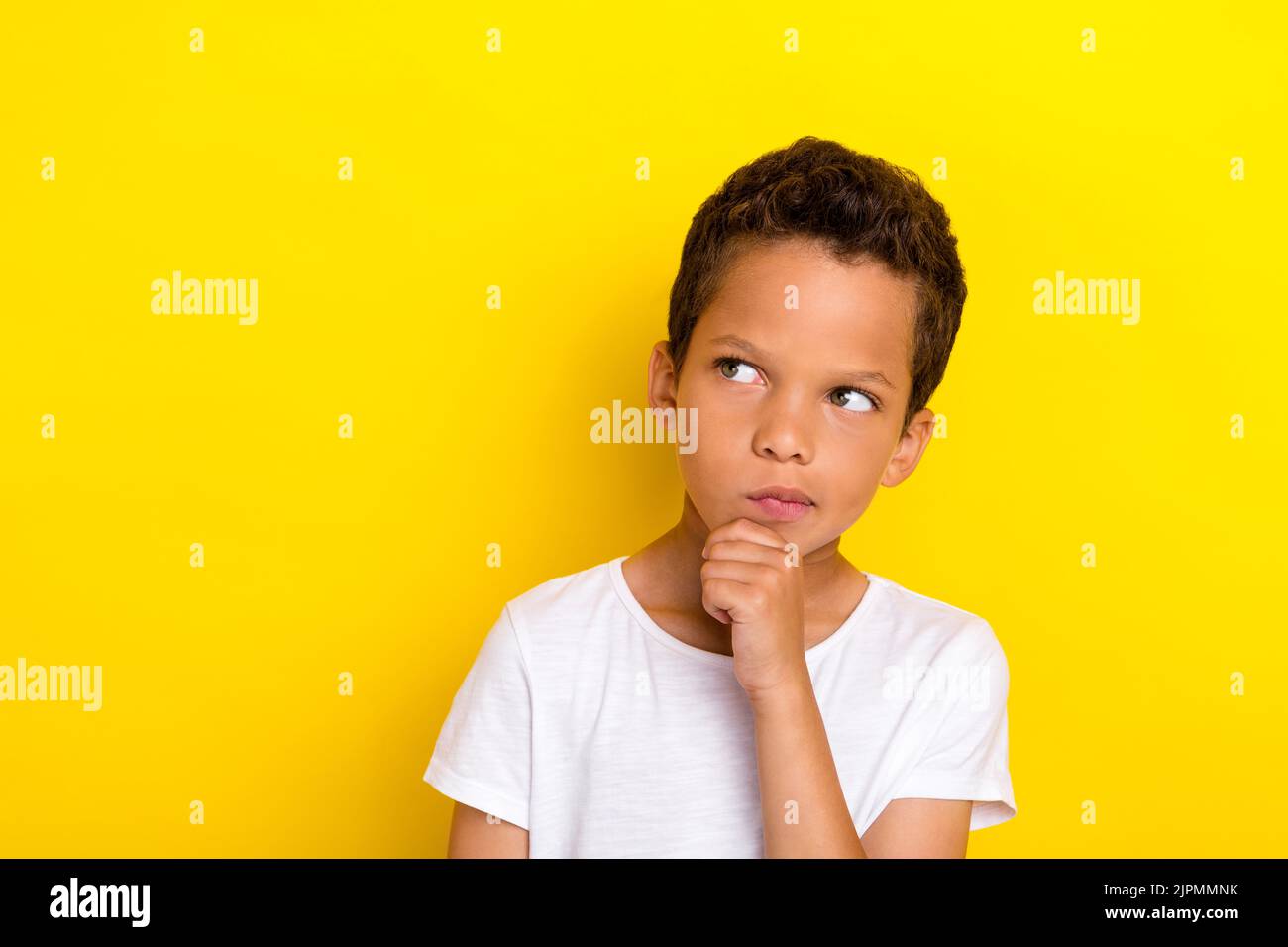 Photo of minded little boy person look empty space arm touch face ...