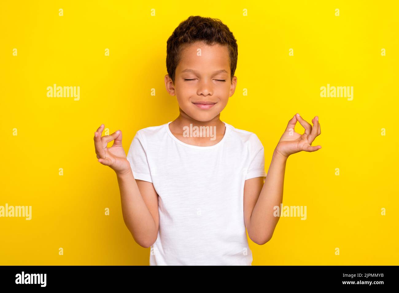 Portrait of attractive calm focused little boy rest relax meditate ...