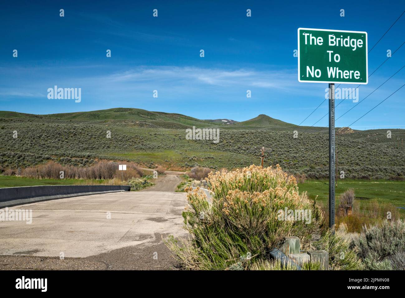 Humorous sign, shrubs growing on bridge, with no road following, near ...