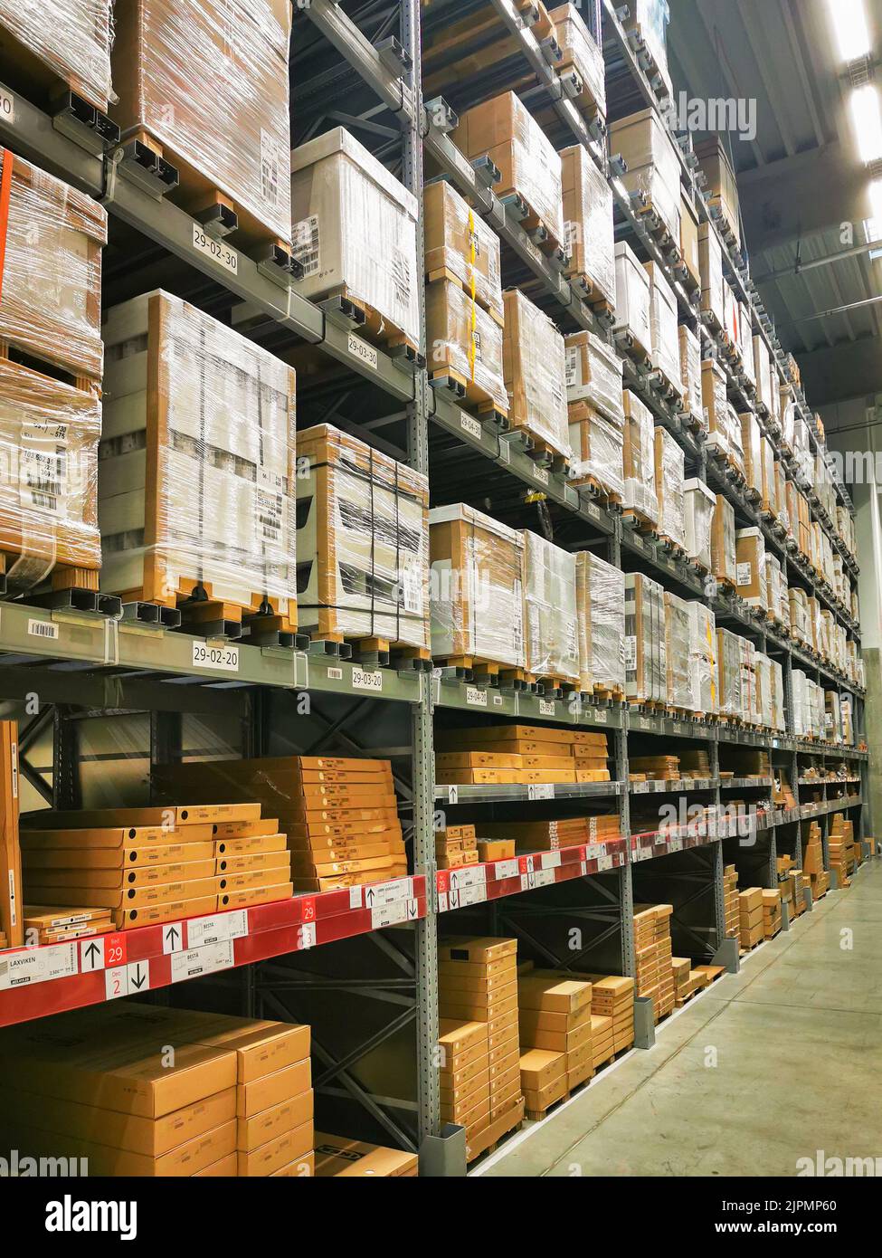 Multi-tiered shelves with goods in a large warehouse Stock Photo - Alamy