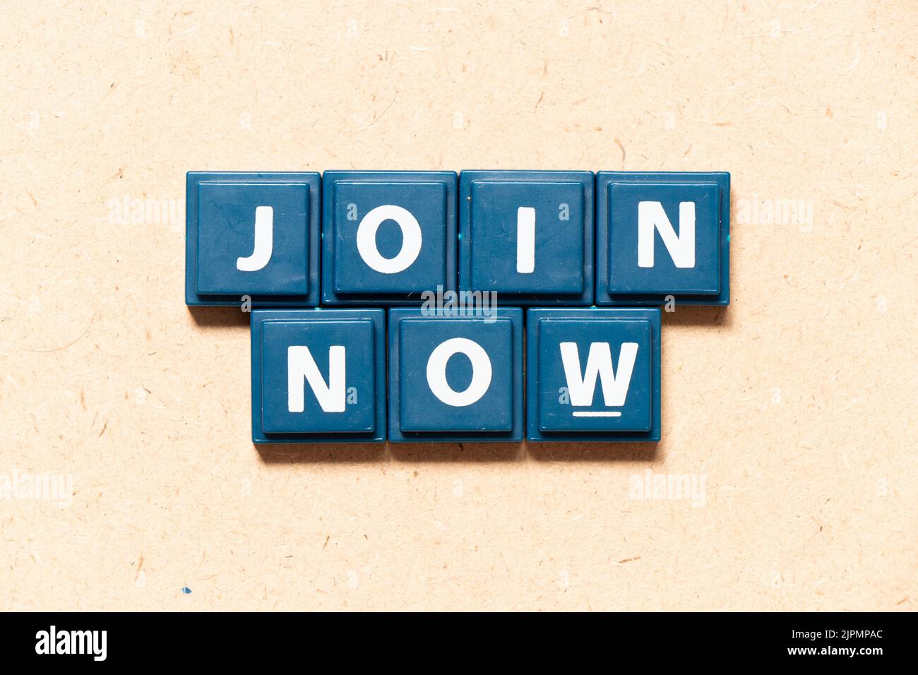 Tile letter in english word join now on wood background Stock Photo - Alamy