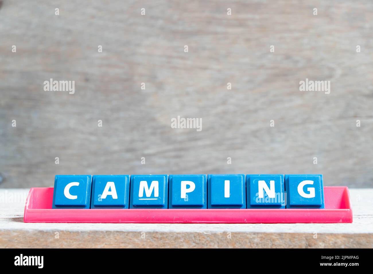 Tile alphabet letter with word camping in red color rack on wood ...