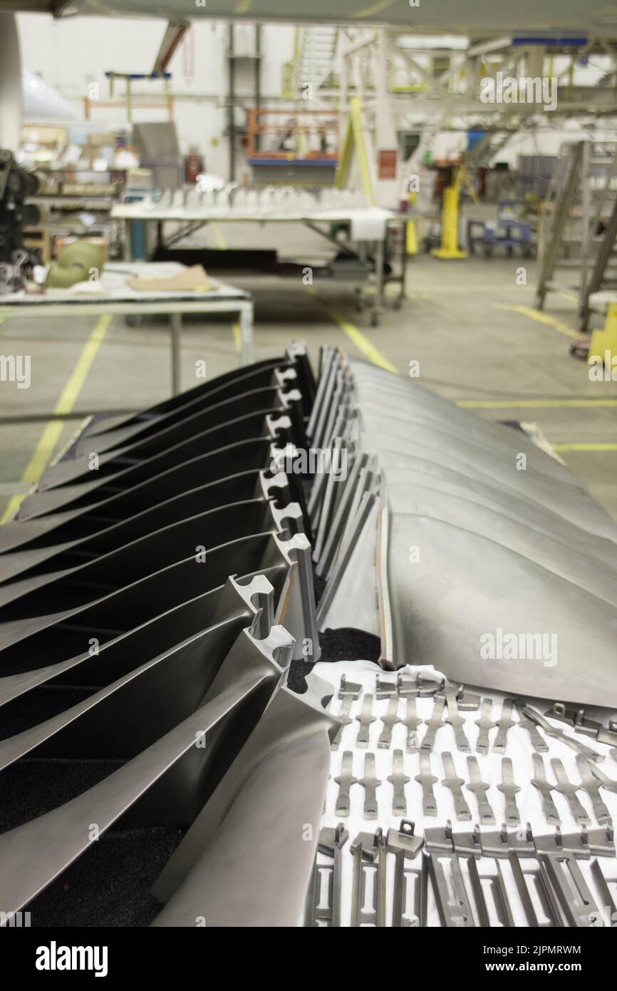 A vertical shot of fan blades from a jet engine on a bench with the ...