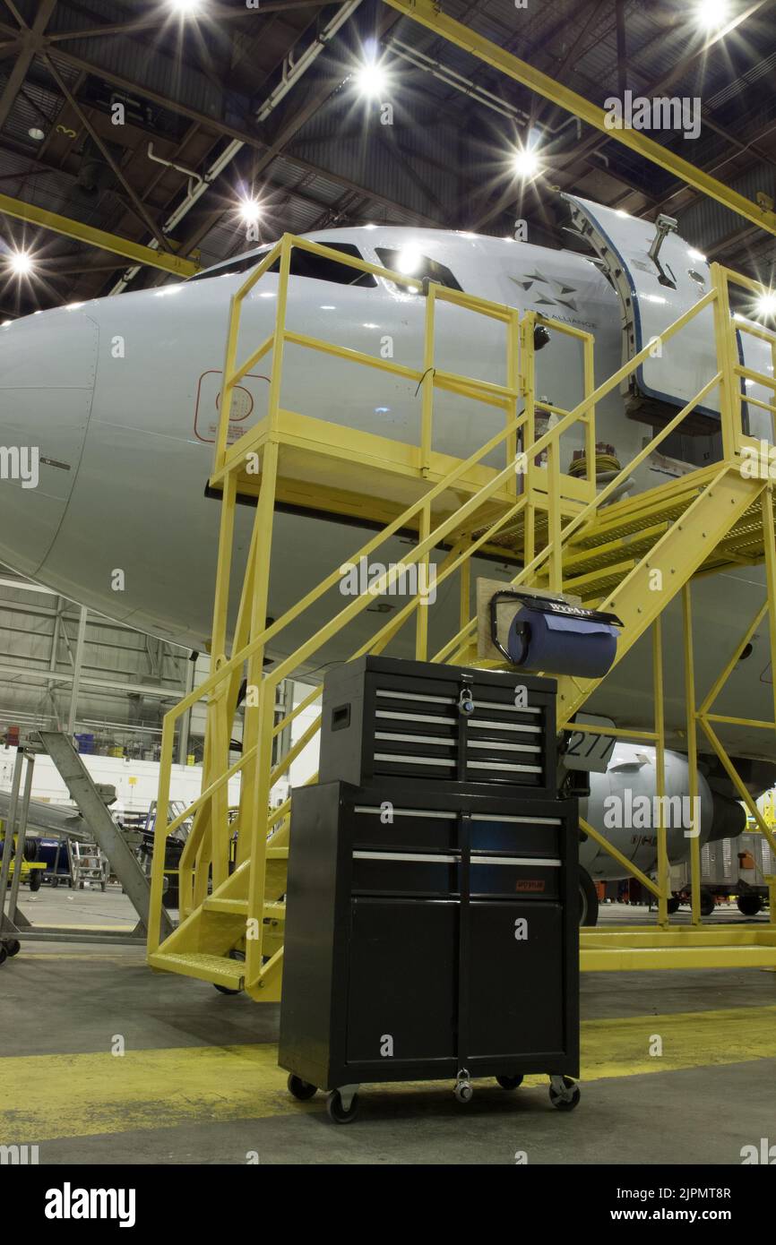 A closeup of an airplane sitting in the maintenance bay with a toolbox ...