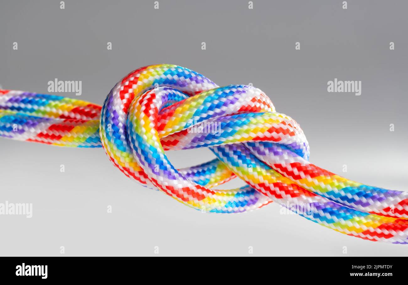 Two colorful braided cords tied together isolated on gray background ...