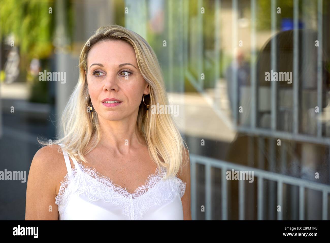 Attractive mature blond woman with a quiet smile and thoughtful ...