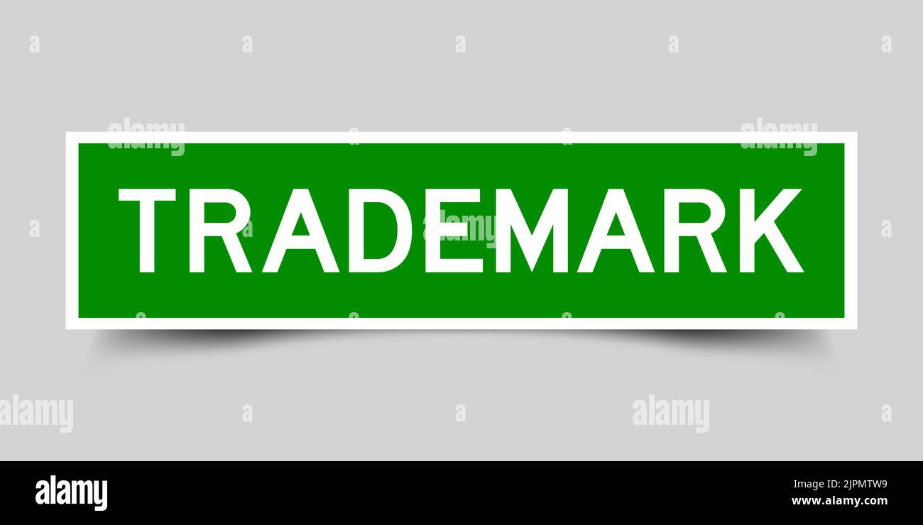 Green color square shape sticker label with word trademark on gray ...