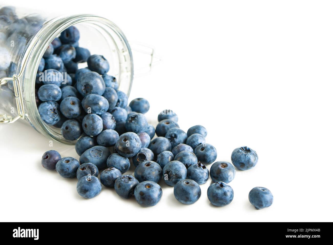Fresh organic blueberries are scattered from glass, isolated on white ...