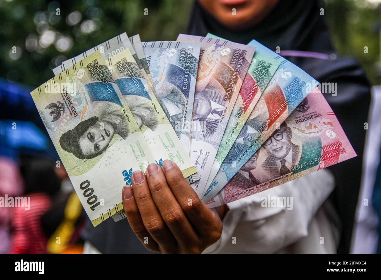 A woman displays new Indonesian banknotes in Bandung. The government of ...