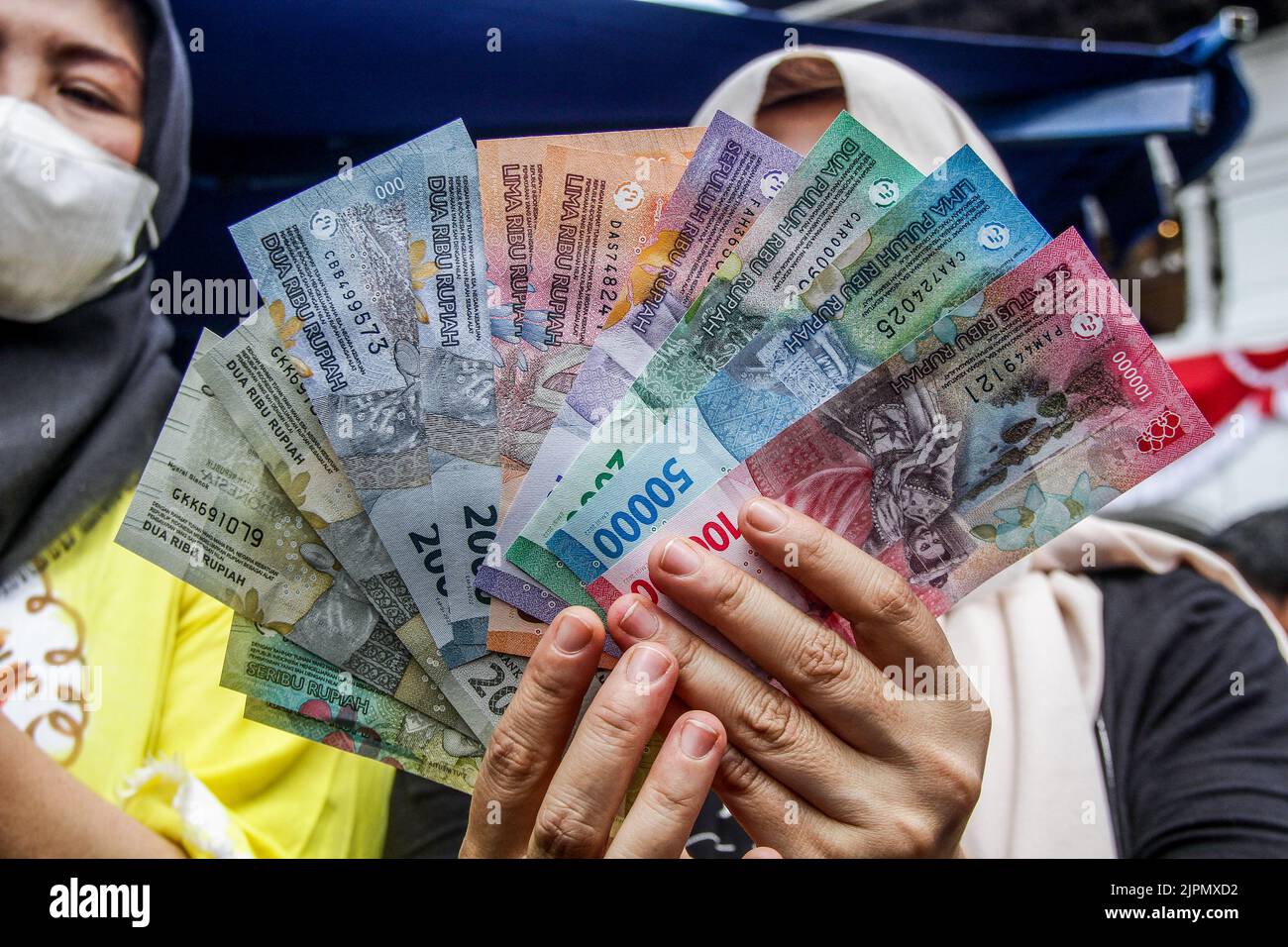 A woman displays new Indonesian banknotes in Bandung. The government of ...
