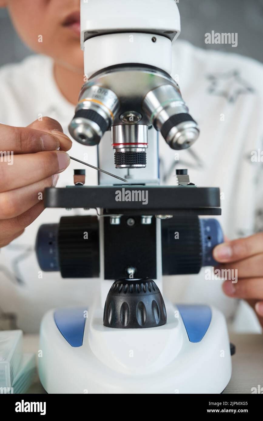 Extreme close-up of unrecognizable student examining sample with help ...