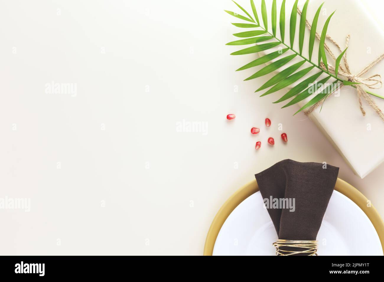 Holiday background. Present with palm leaf, table settings and ...