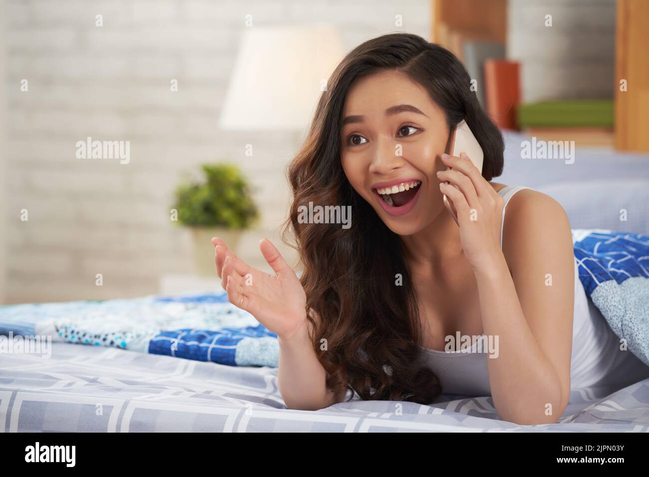 Happy excited Asian woman talking on phone Stock Photo - Alamy