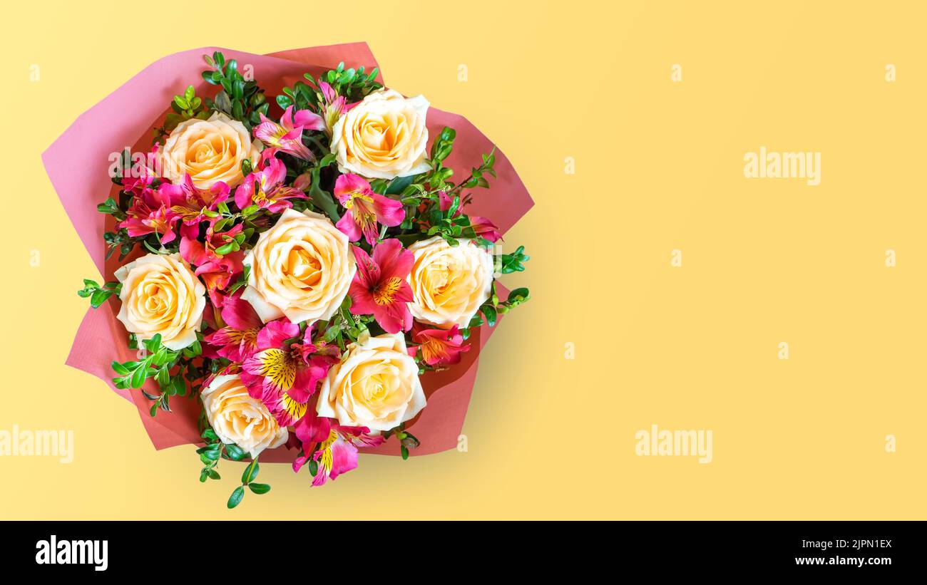 Bouquet of beautiful roses and alstroemeria on yellow background. Fresh ...