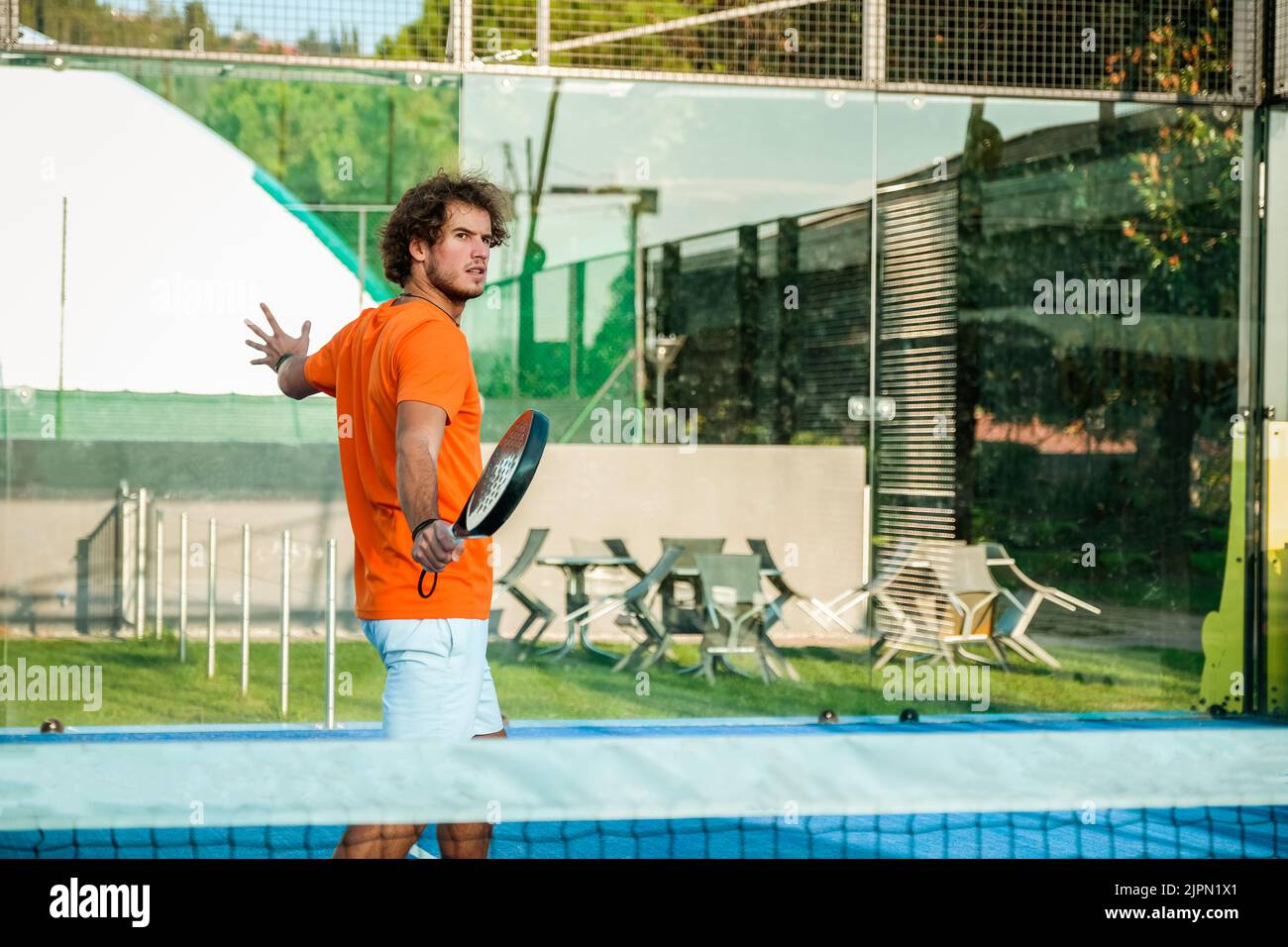 Padel match in a blue grass padel court - Padel player playing a match ...