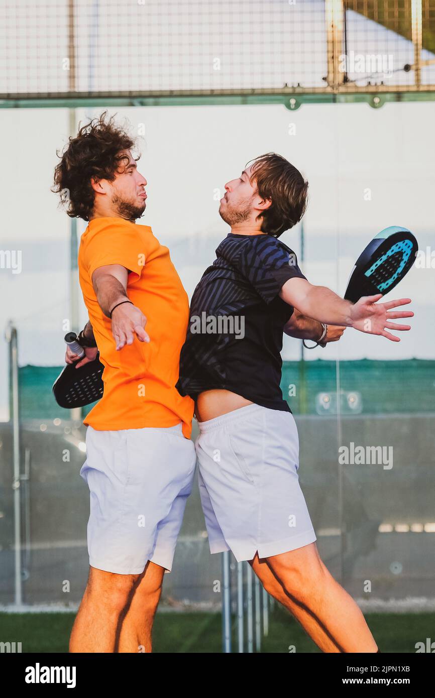 Portrait of two smiling sportsman's posing on padel court outdoor with ...
