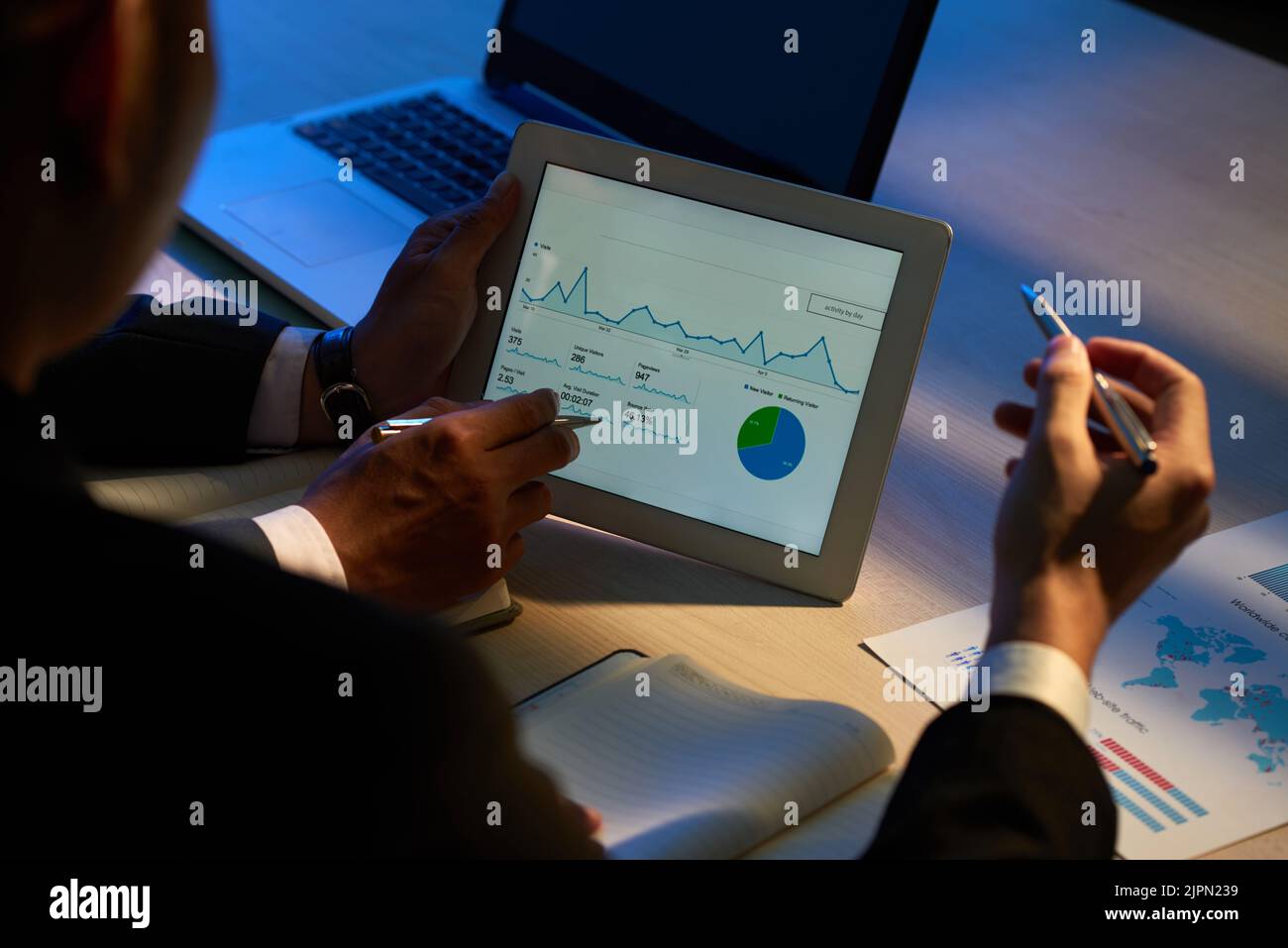 Businessman showing statistics on digital tablet to coworkers Stock ...