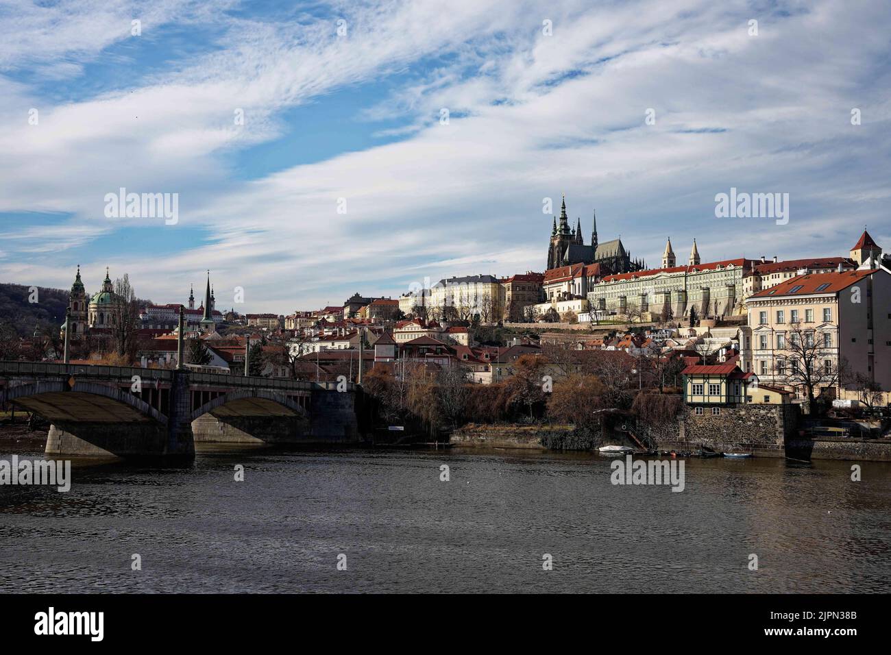 The Vltava River under a blue cloudy sky over a background of Prague ...