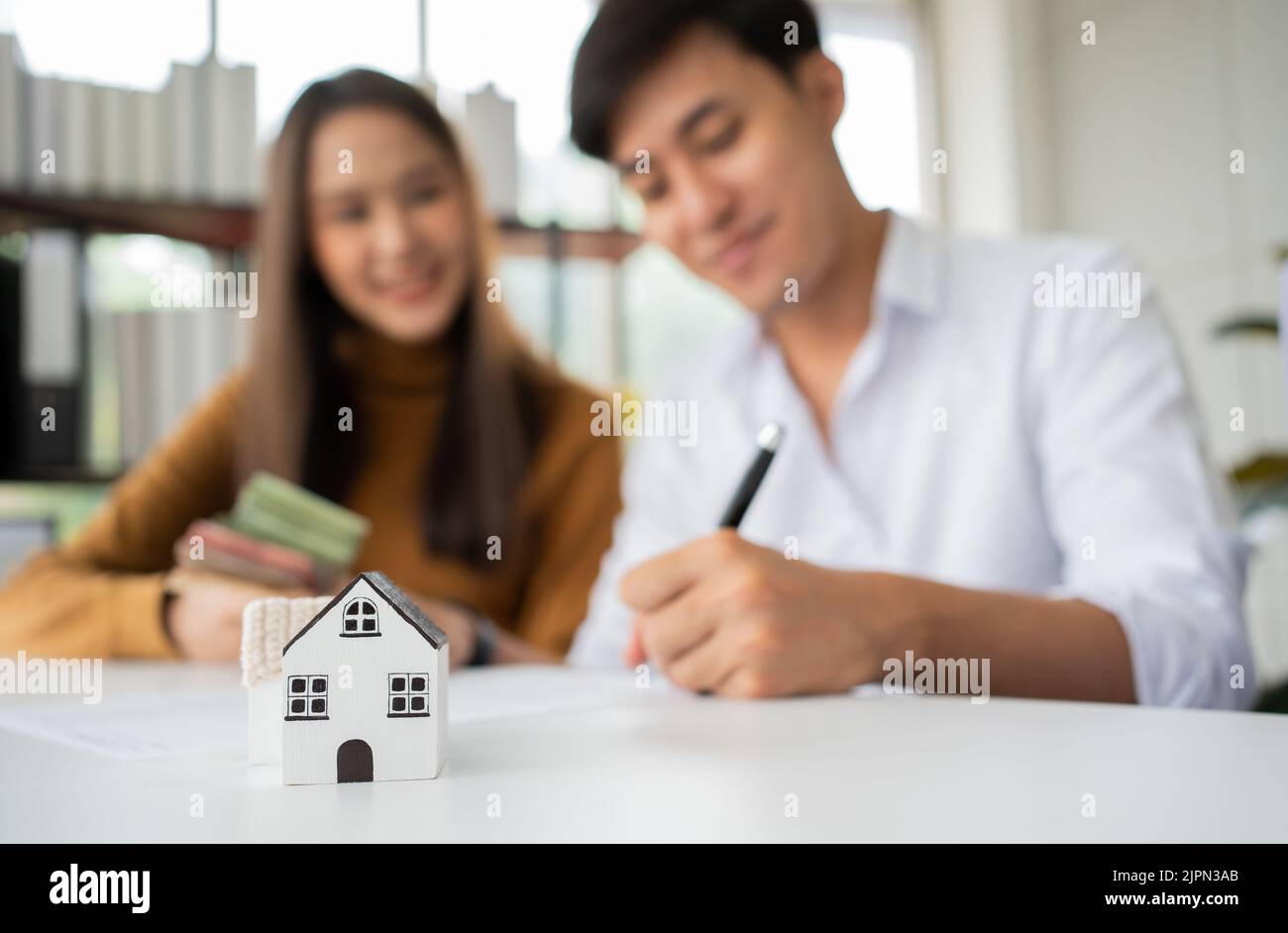 Client signs home loan document to buy homes with real estate property ...