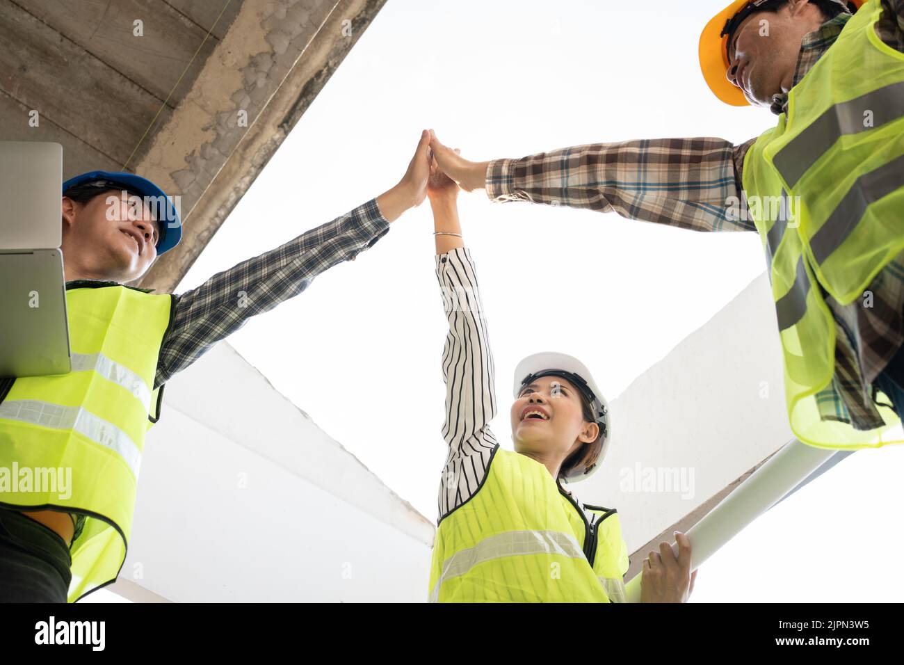 Engineer team and contractor raise their hands up together for joining ...