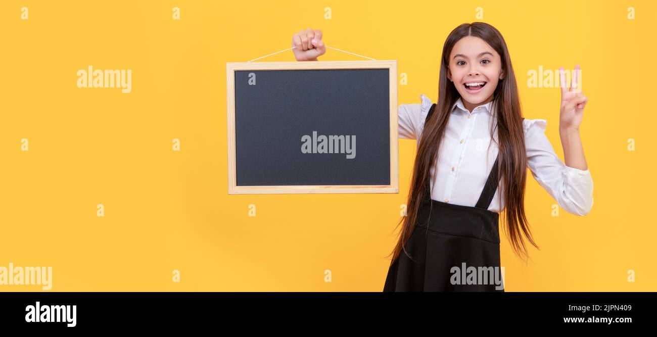 smiling teen girl in uniform hold school blackboard for copy space ...