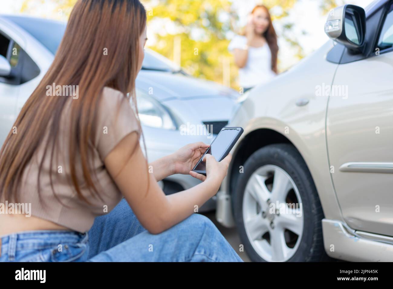 Two drivers check for damage after a car accident before taking ...